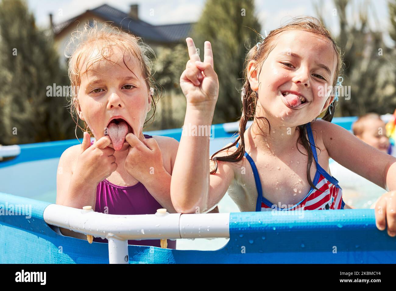Siblings playing in a pool hi-res stock photography and images - Alamy