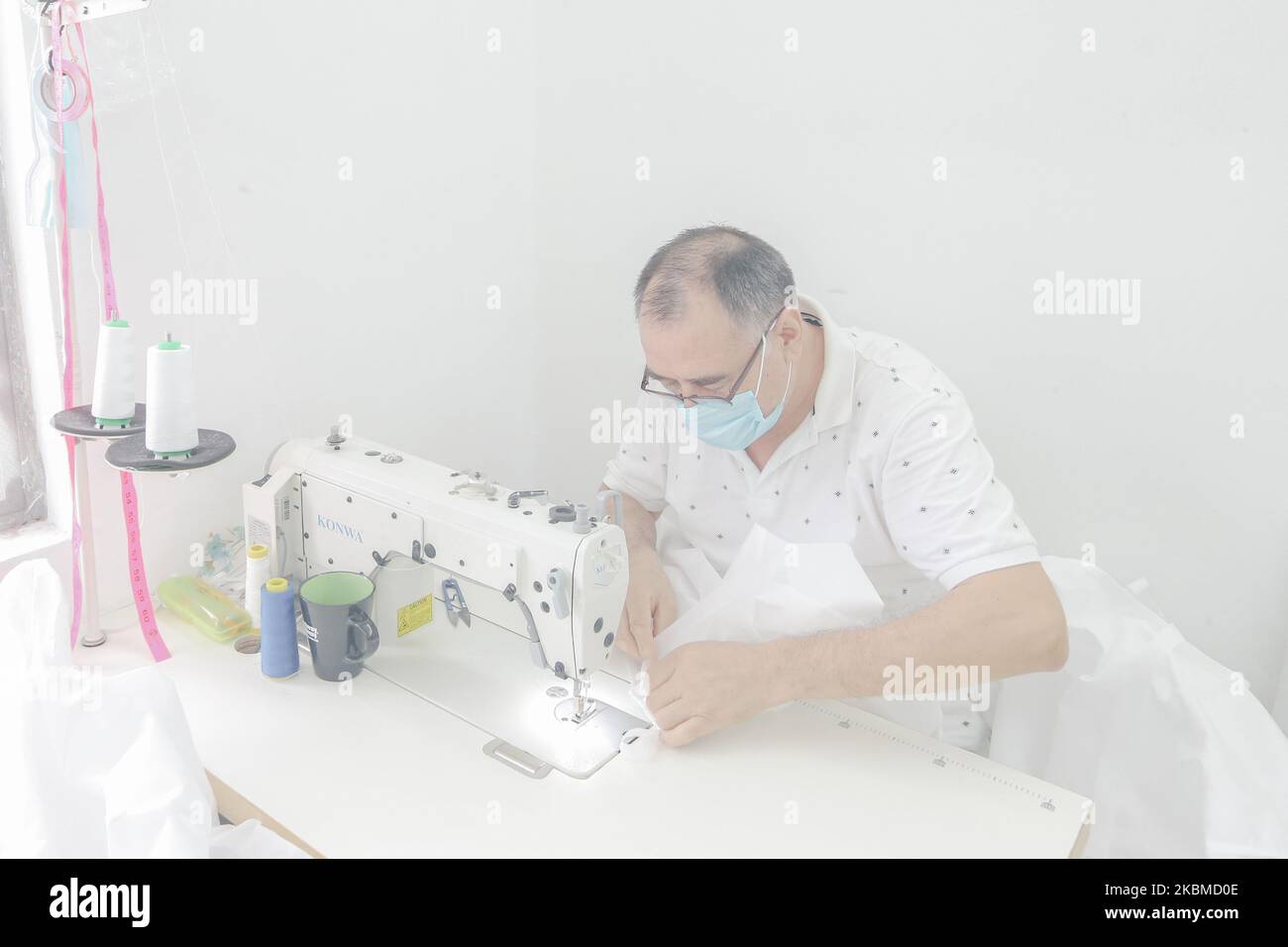 An Afghan refugee living in Malaysia sewing the Personal Protection ...