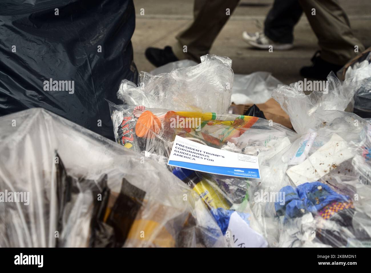 A coronavirus mailer from President Trump lies in a streetside garbage ...
