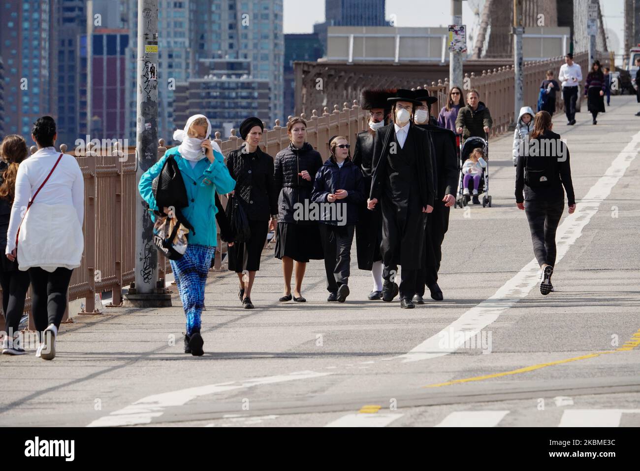A family of Orthodox Jewish people walk along Brooklyn bridge in ...