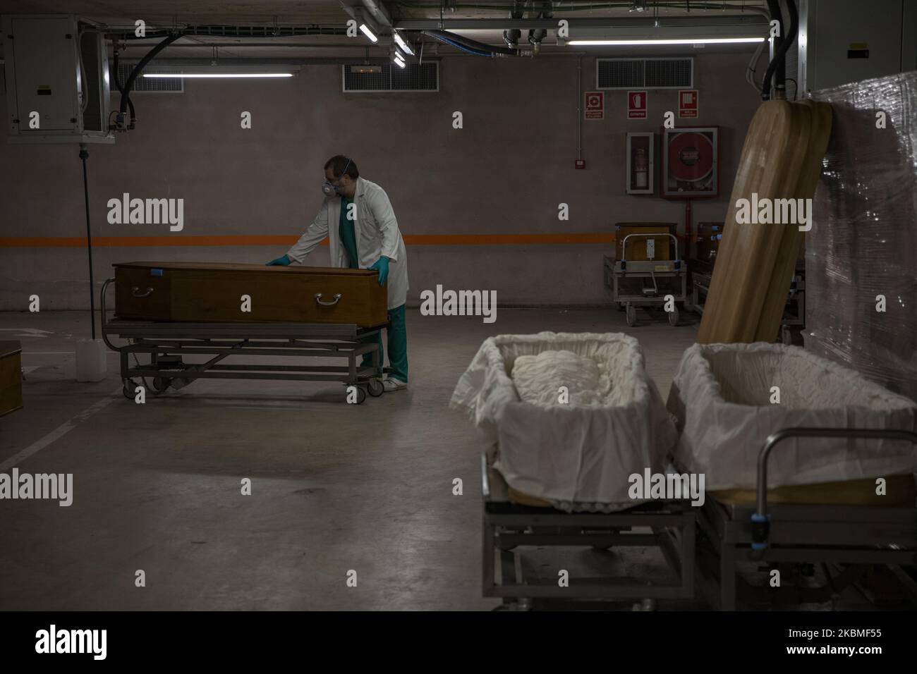 A worker moves coffins with the bodies of people who dead of ...