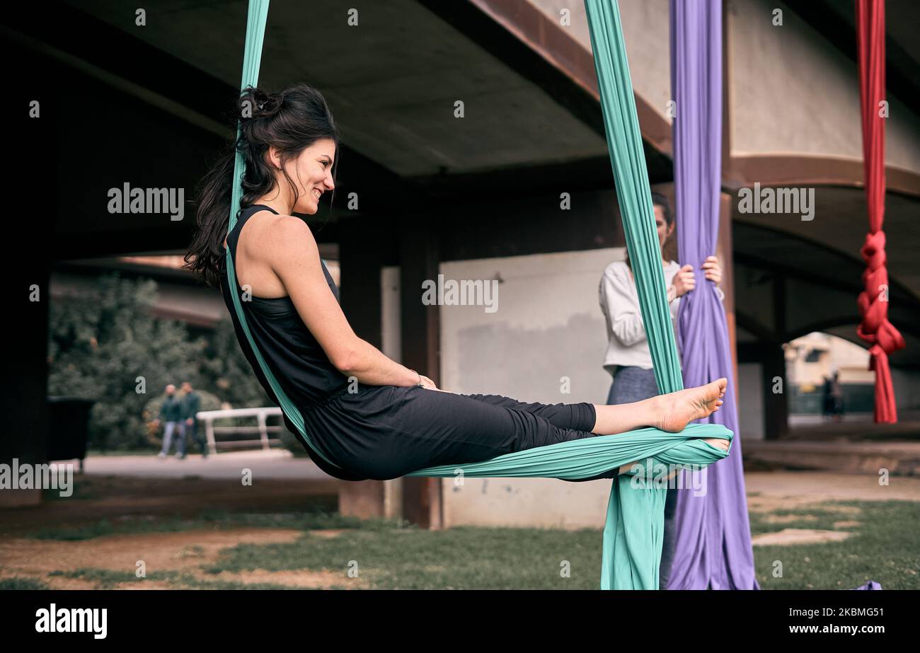 Young caucasian woman winding up whilst using her stretch fabric as a ...