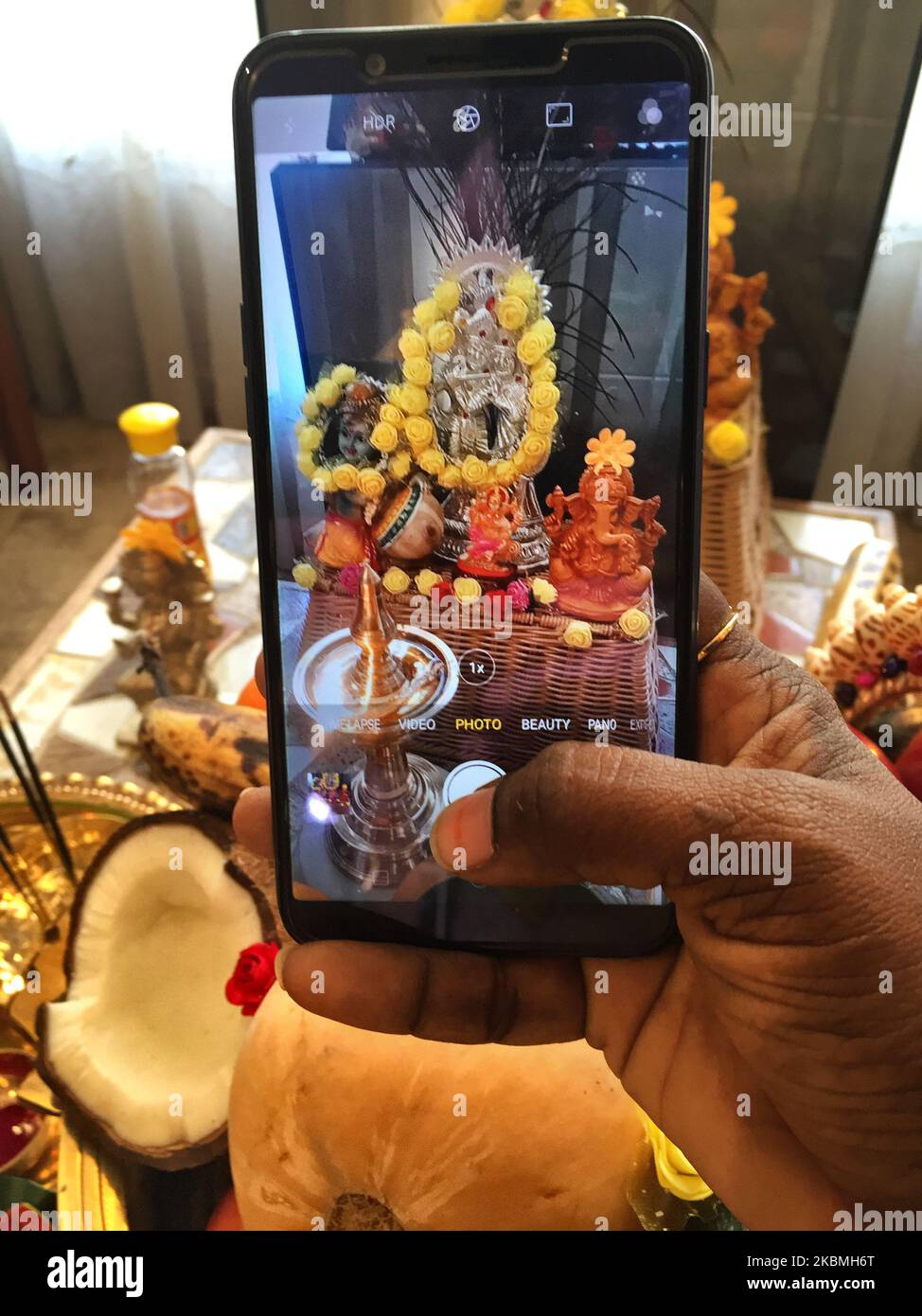 Woman takes a photo of a traditional Vishu kani (Vishukani) setting ...