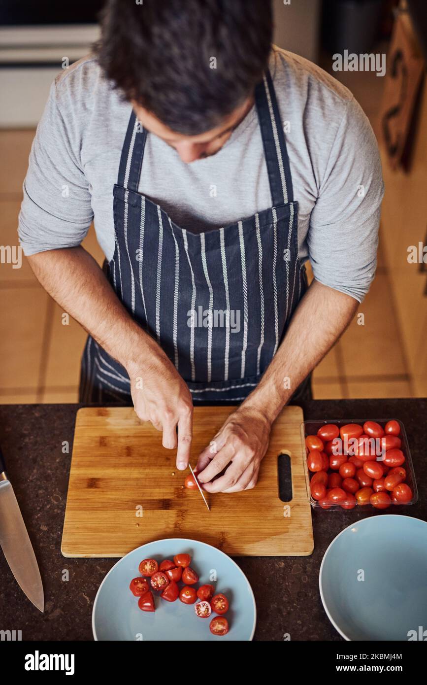 Slicing his way to a summer salad. High angle shot of an unidentifiable ...