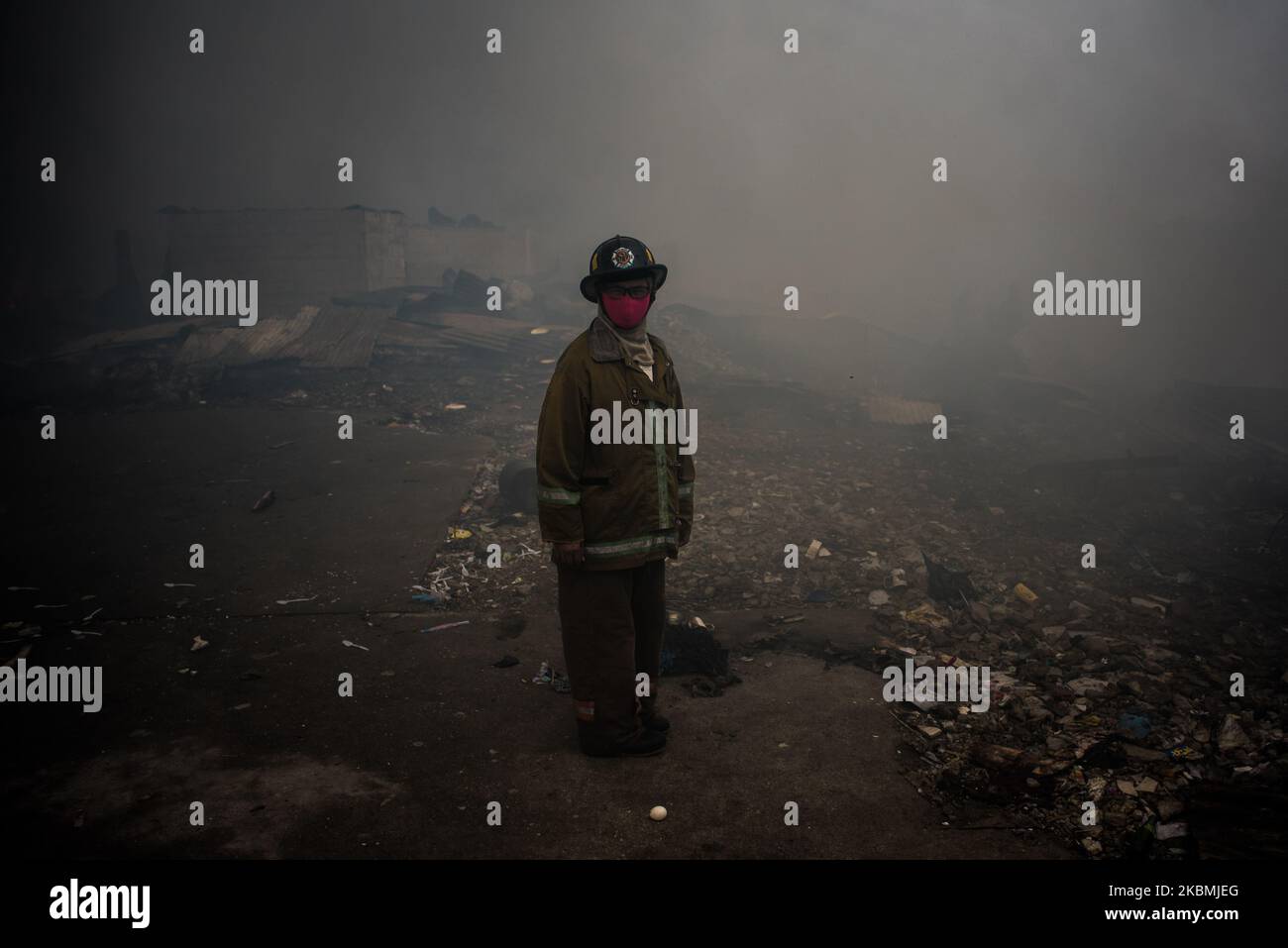 A firefighter stands at the scene of fire in a slum area in Tondo ...