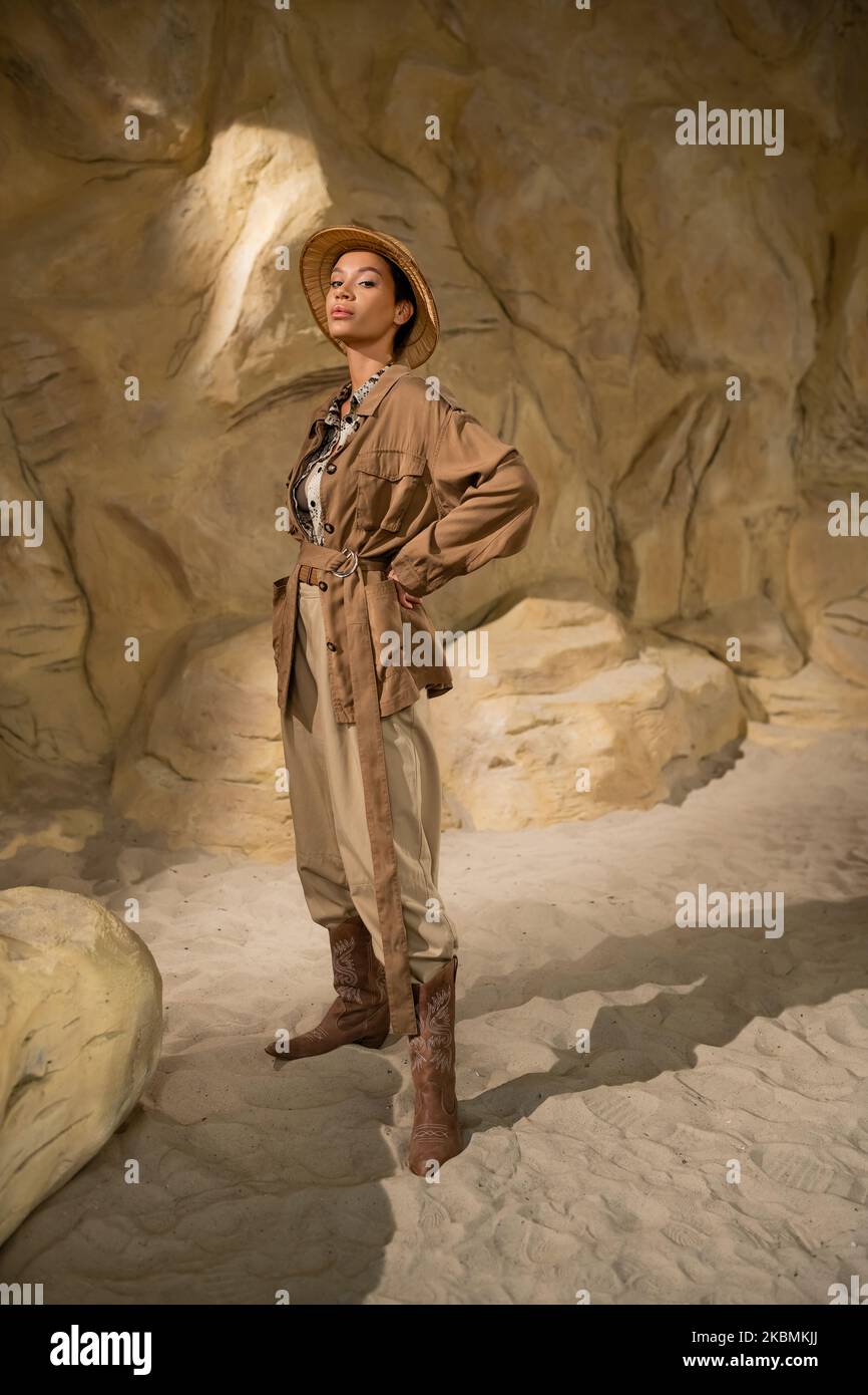 full length of archaeologist in safari hat and beige clothes standing ...