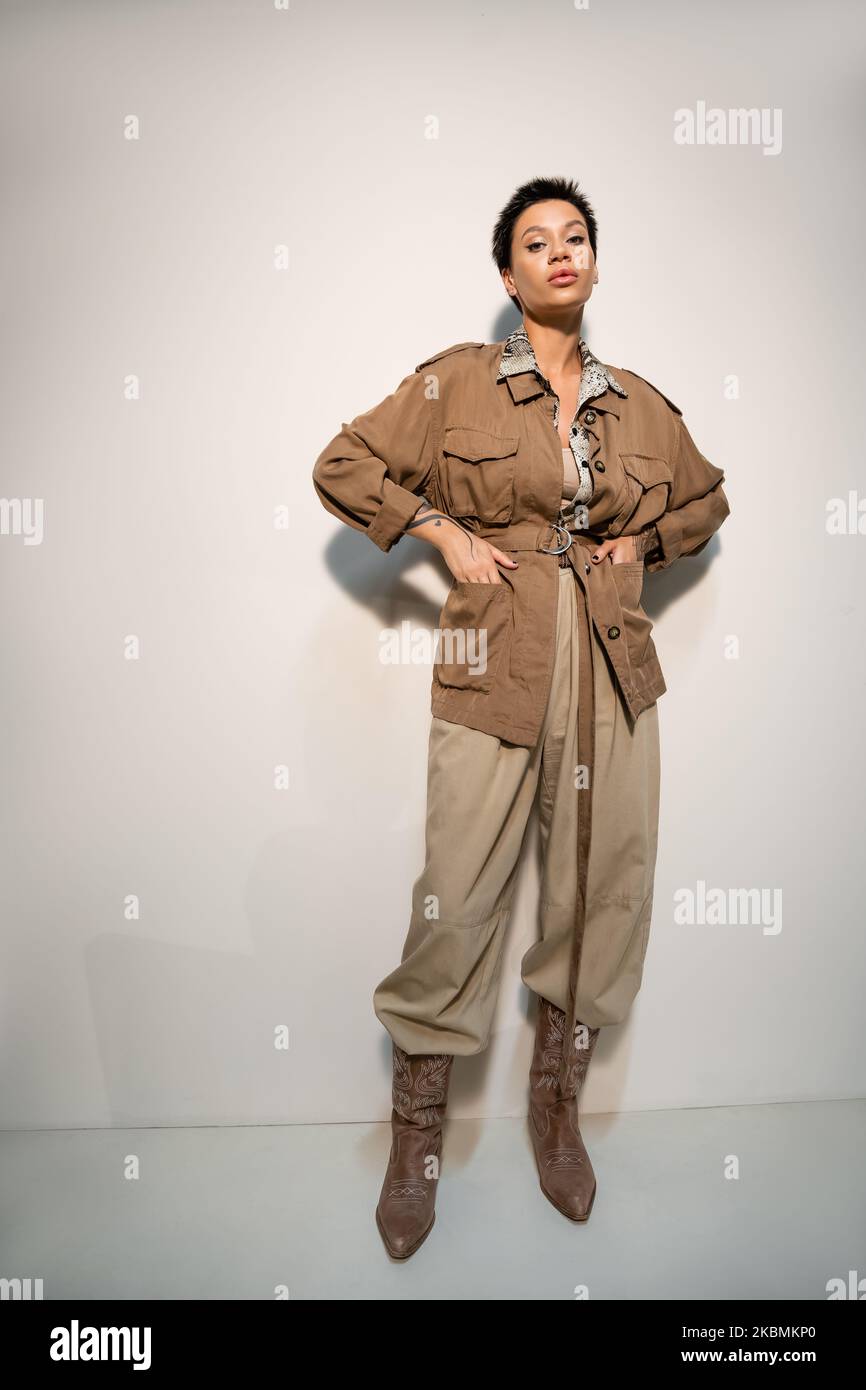 full length of brunette archaeologist in safari style outfit standing ...