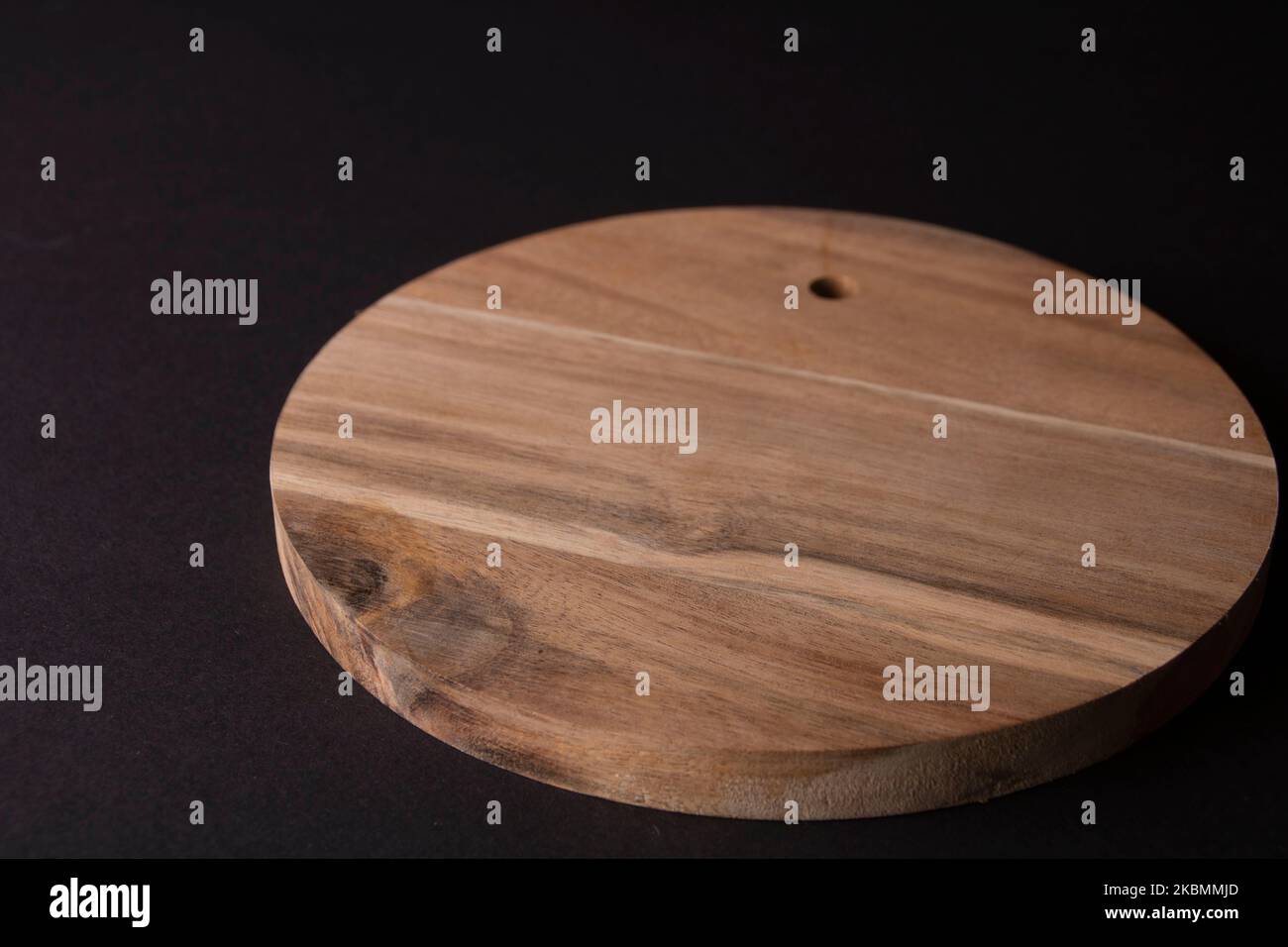 round wooden cutting board with black background Stock Photo - Alamy