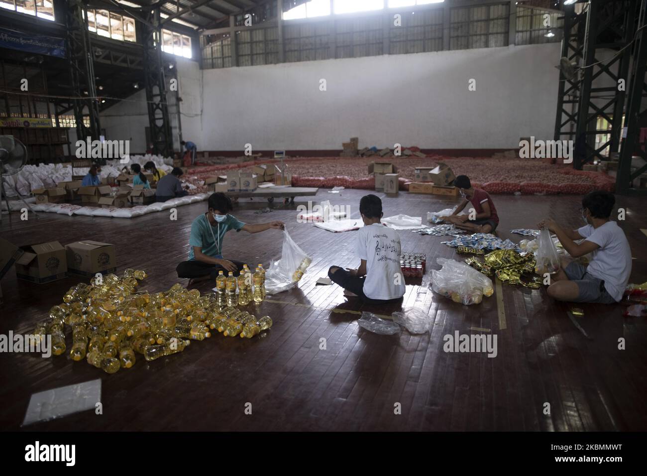 Volunteers prepare prepare packages of dry rations of food and ...