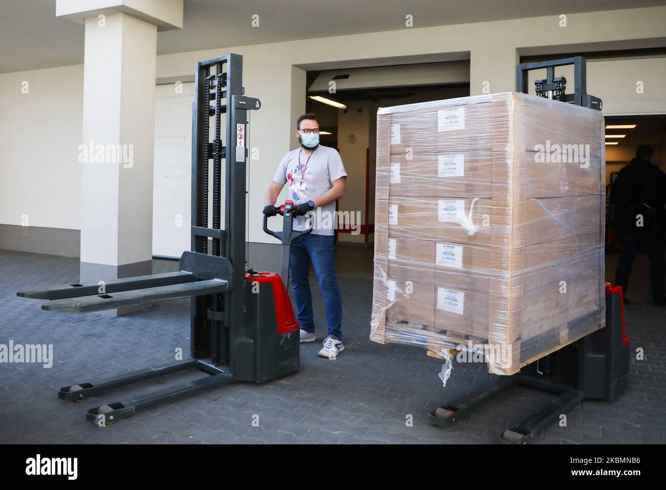 Workers unload pallets of medical supplies for healthcare personel ...