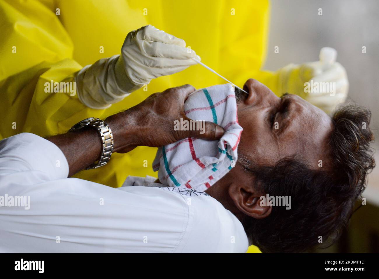 Sri Lankan health worker (L) uses a swab to collect a sample for COVID ...