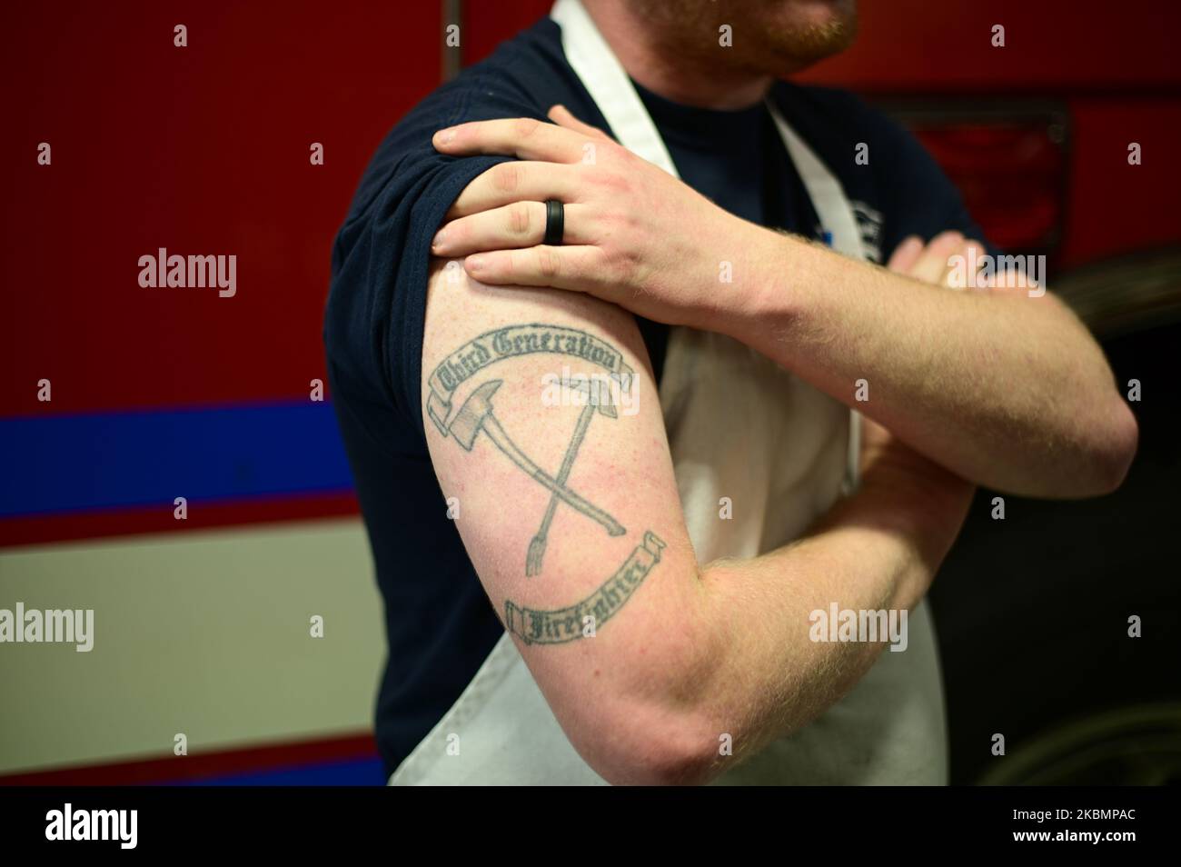 Thrid generation firefighter AJ Alves, 25 shows his tattoo as he poses ...