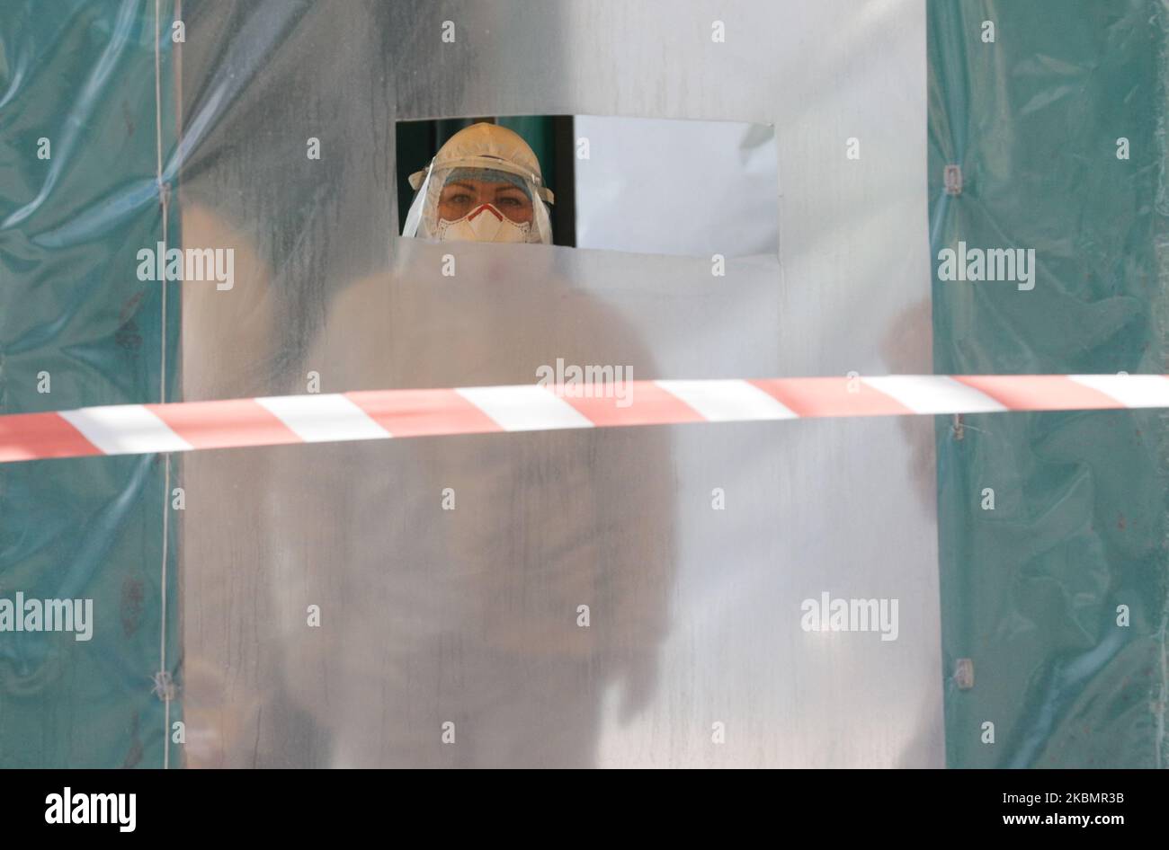 An epidemiologist stands in the tent set next to the soviet era ...