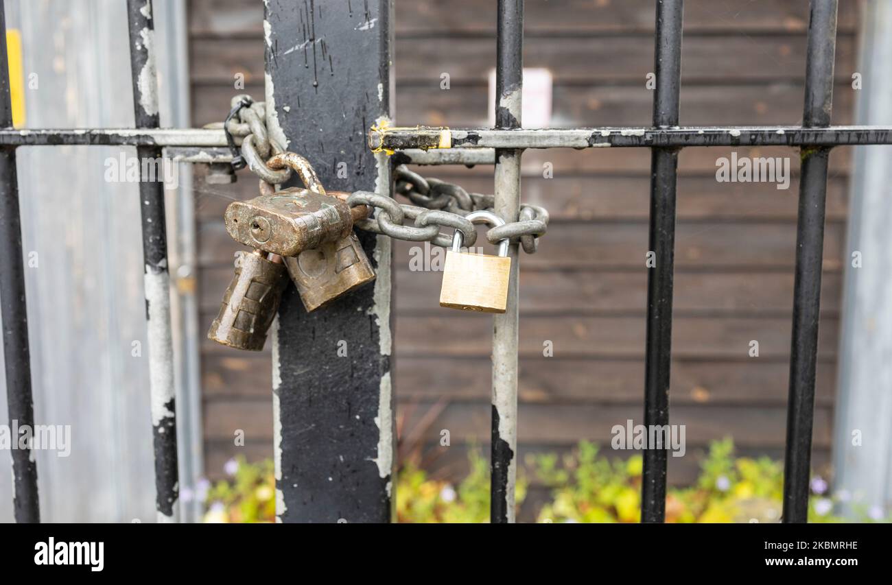 Closed on a chain padlock hanging on a metal gate Stock Photo - Alamy
