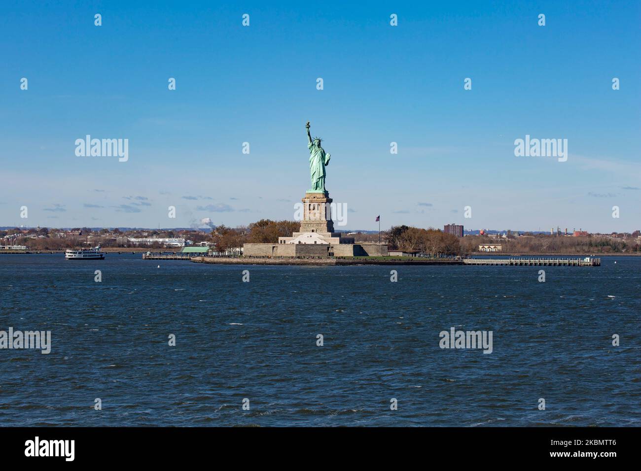 Statue of Liberty as seen during a blue sky cloudless day with tourists ...
