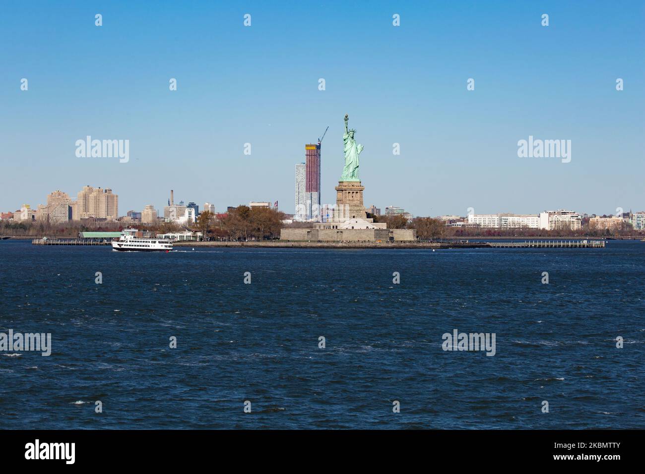 Statue of Liberty as seen during a blue sky cloudless day with tourists ...