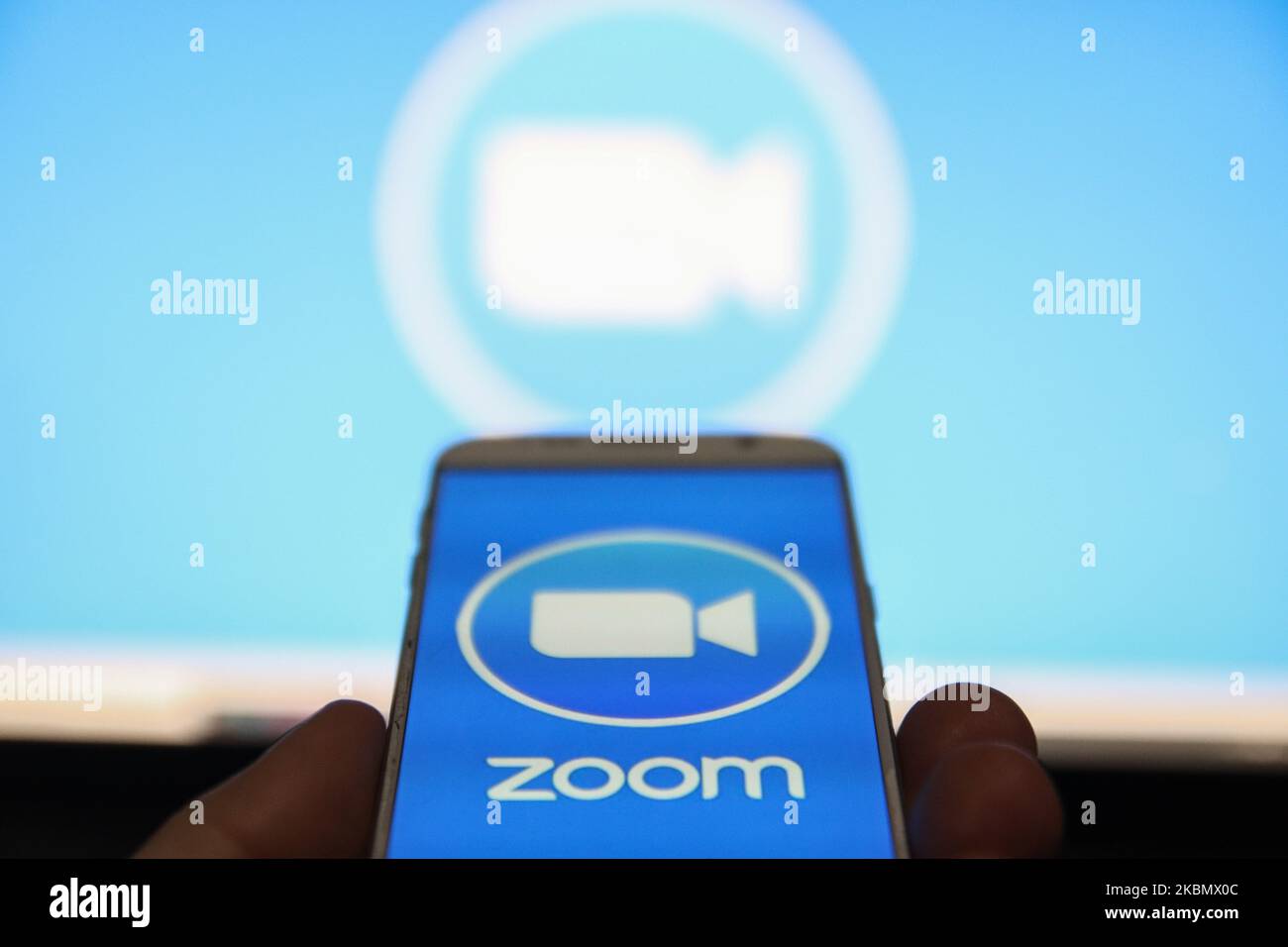 ZOOM Video Communications logo displayed on a phone screen, thumbnails ...