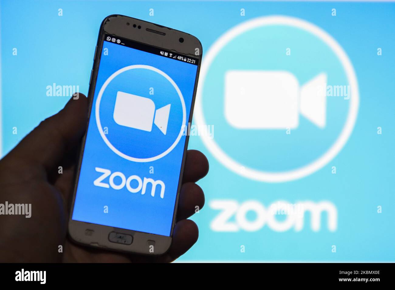 ZOOM Video Communications logo displayed on a phone screen, thumbnails ...