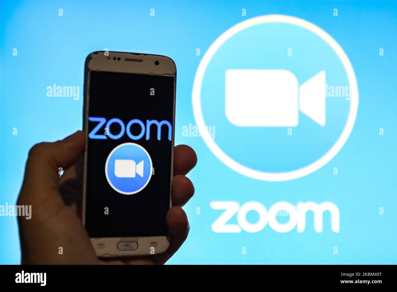ZOOM Video Communications logo displayed on a phone screen, thumbnails ...