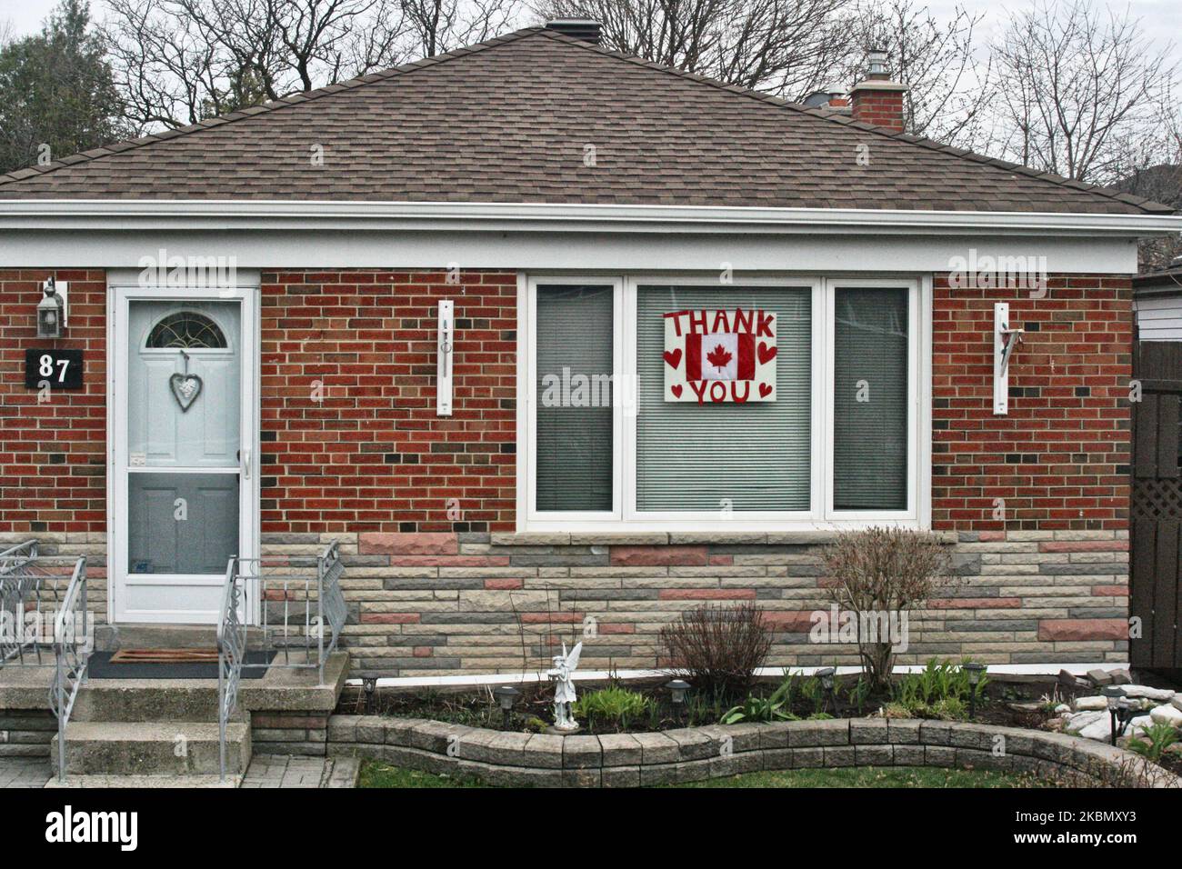 Canadian flag in the window of a home with the words 'thank you' as a ...