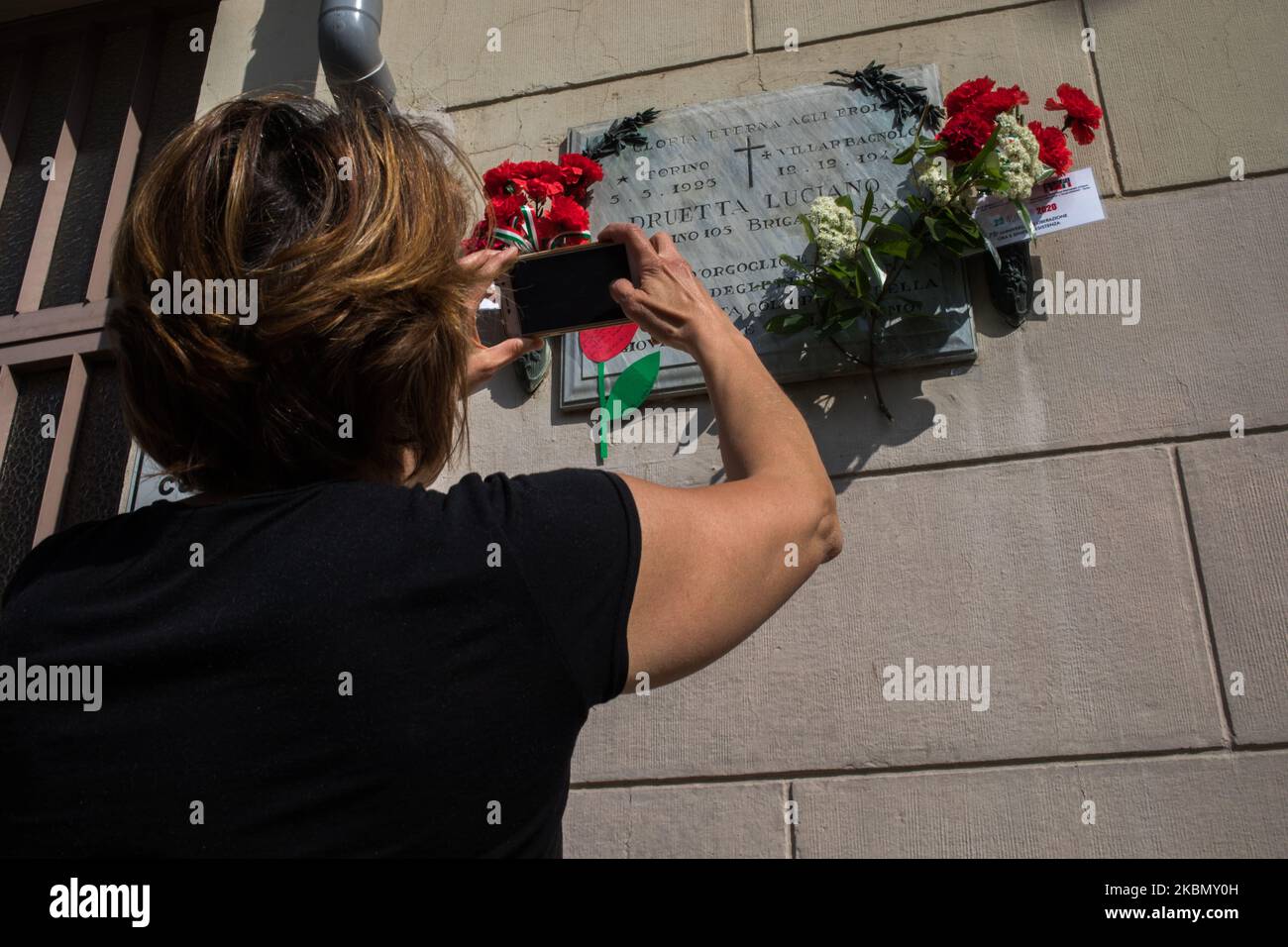 Turin, Italy 25 April 2020. A lady brings flowers and a drawing make ...