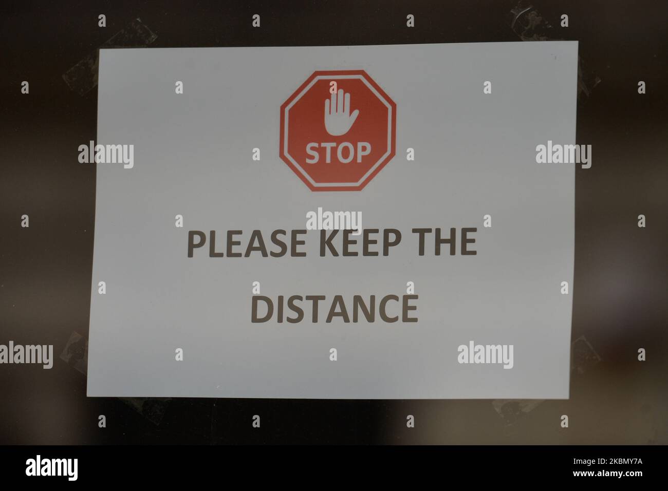 Please Keep The Distance sign seen on a shop door, in Krakow city ...