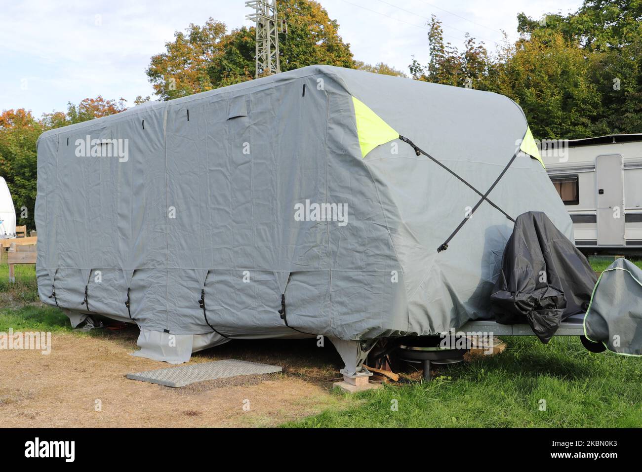 a caravan with a gray tarpaulin Stock Photo - Alamy