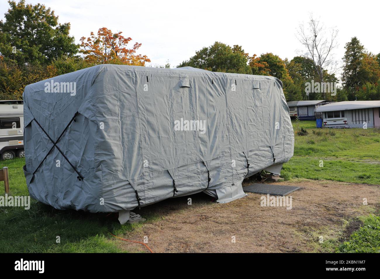 a caravan with a gray tarpaulin Stock Photo - Alamy