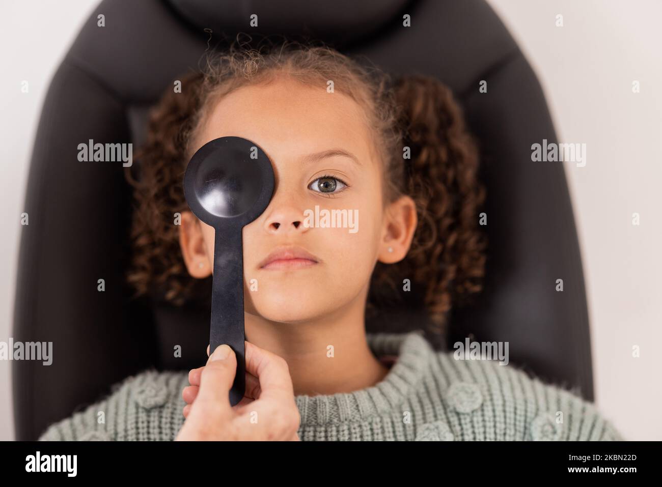 Optometry, eye care and girl getting a vision test with a occluder in a ...