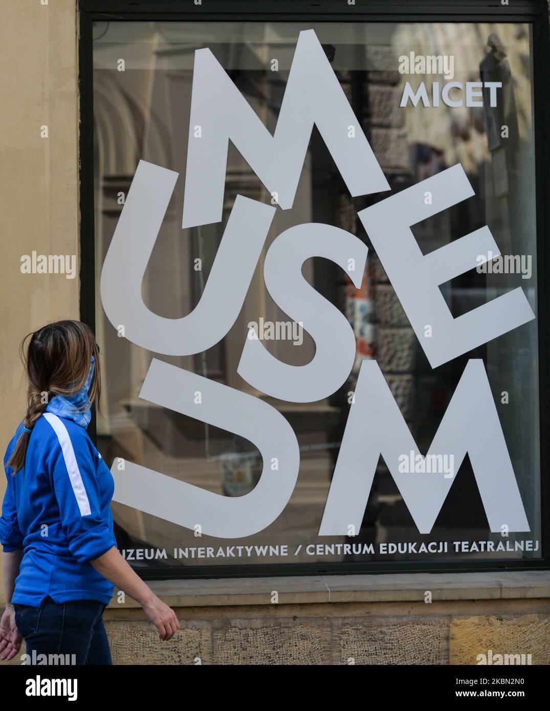 A lady passes outside a closed museum window in krakow city center ...