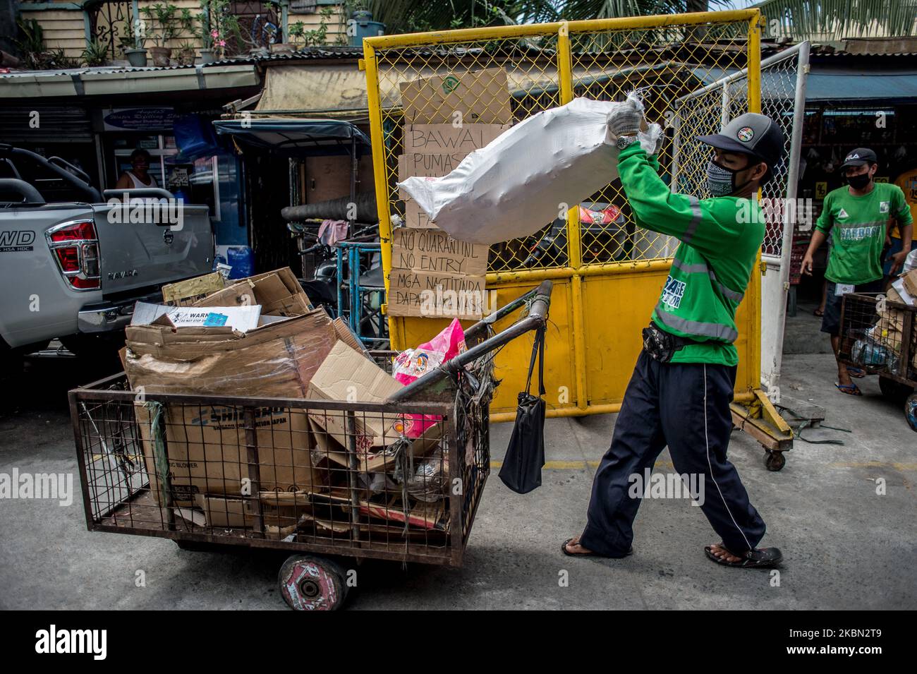 Alquin Flores, a garbage collector, collects household waste in a ...