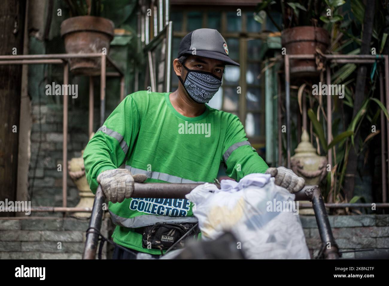 Alquin Flores, a garbage collector, collects household waste in a ...