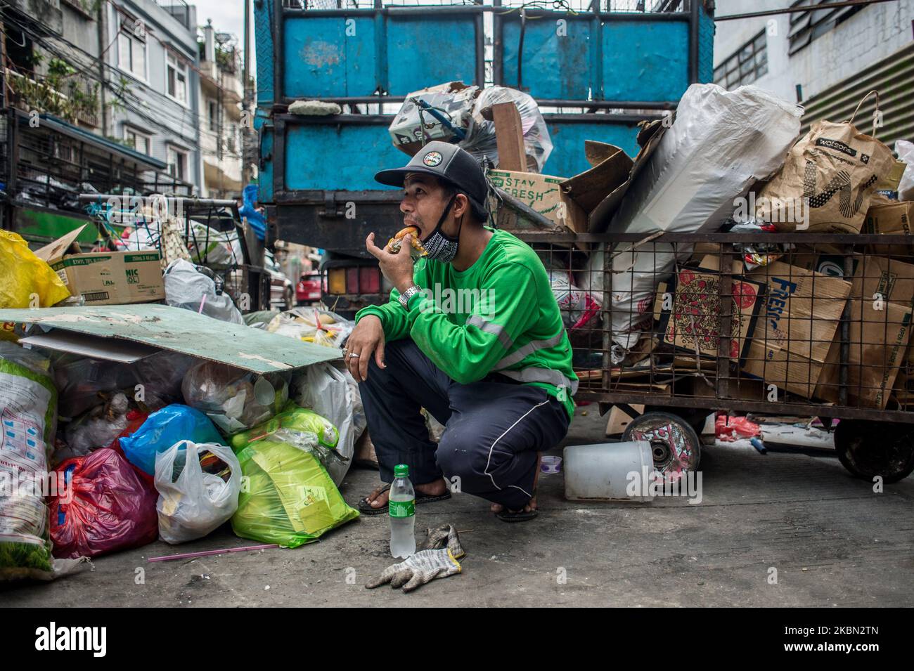 Alquin Flores, a garbage collector, takes a break after collecting ...