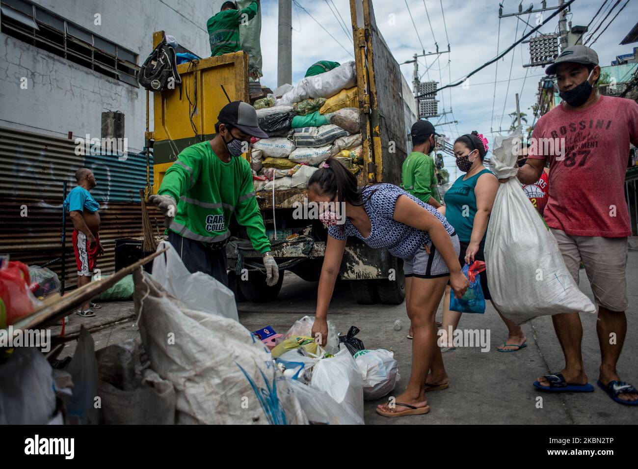 Residents bring out their household waste for garbage collectors to ...