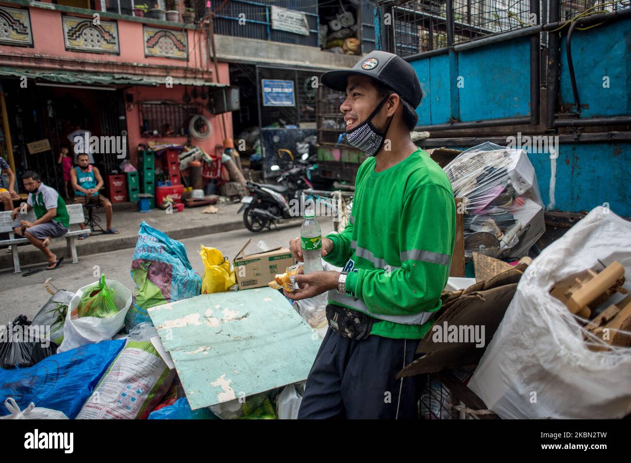 Alquin Flores, a garbage collector, takes a break after collecting ...