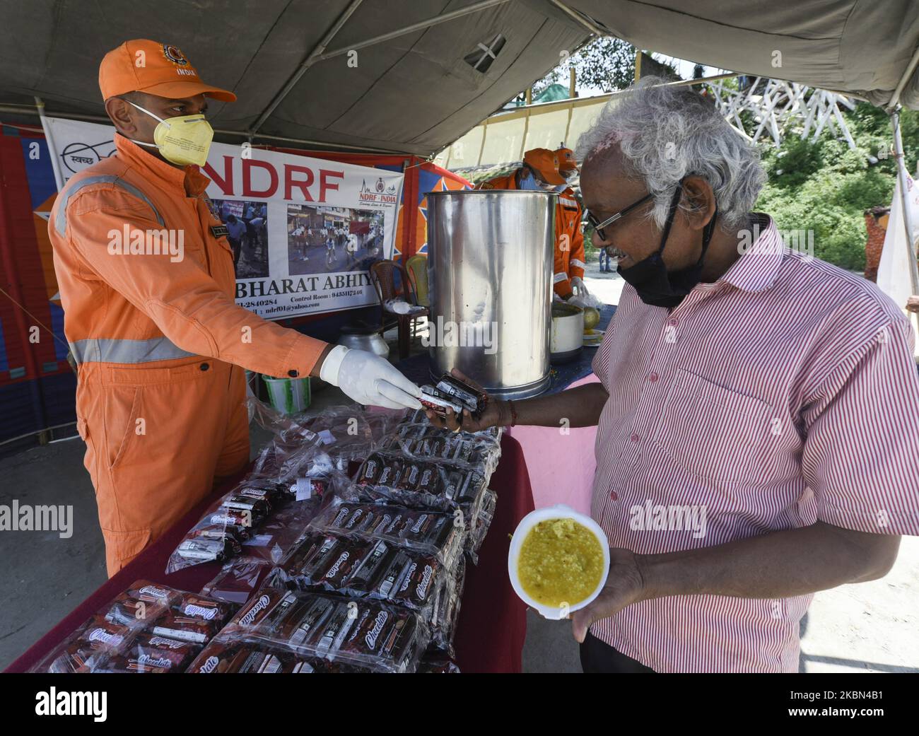 National Disaster Response Force (NDRF) personnel distribute foods to ...