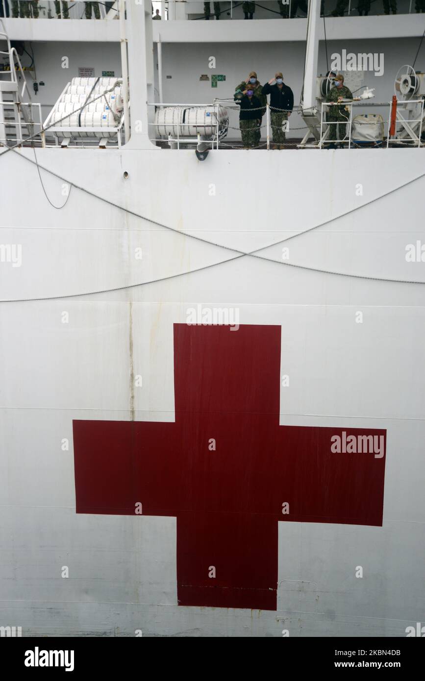 US Navy Medical personnel man the rails of the hospital ship Comfort as ...