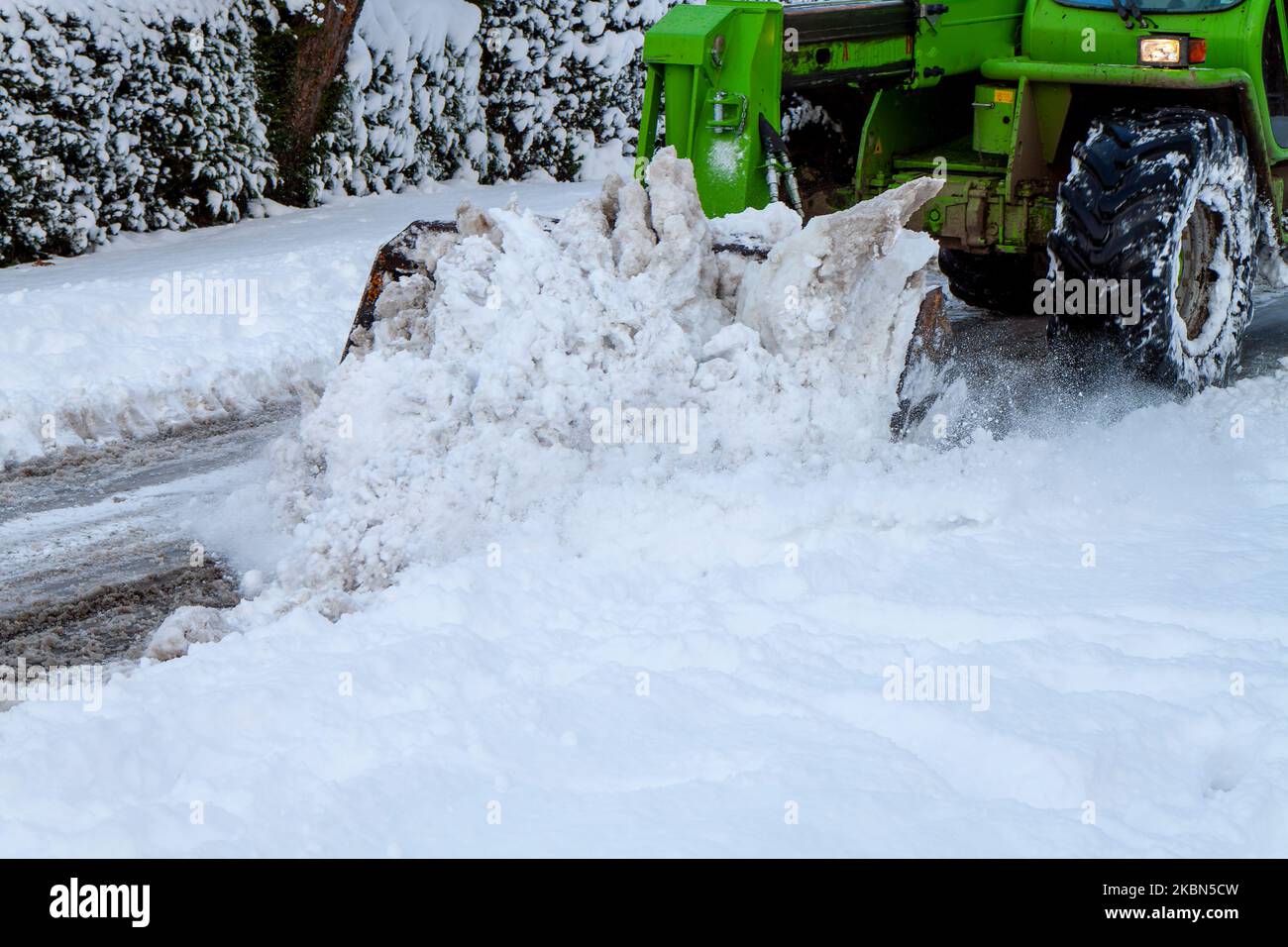 Tractor snow plough clearing the road Stock Photo - Alamy