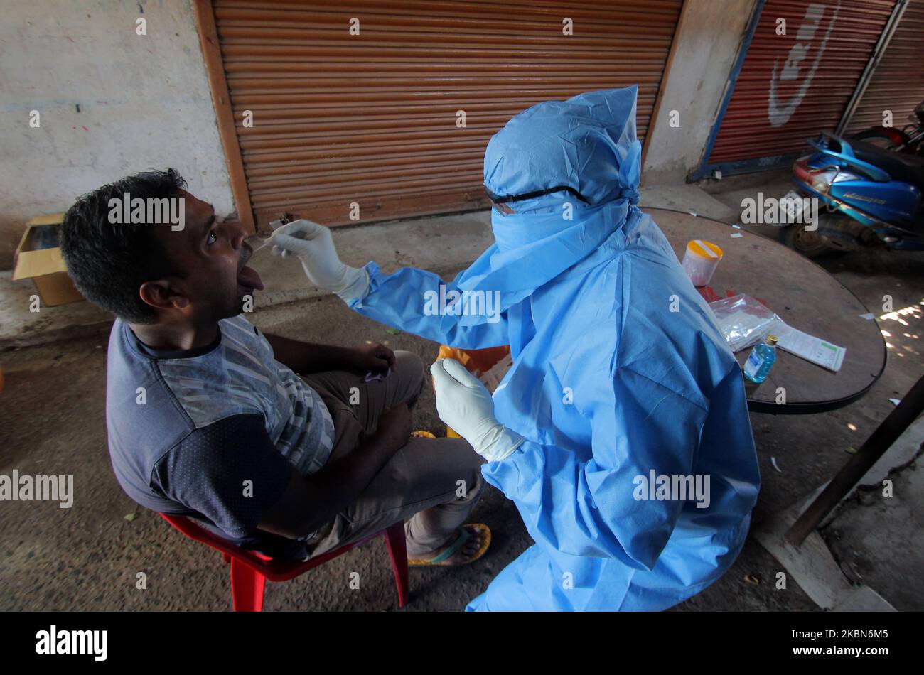 Health department workers are seen as they collects swab for COVID-19 ...