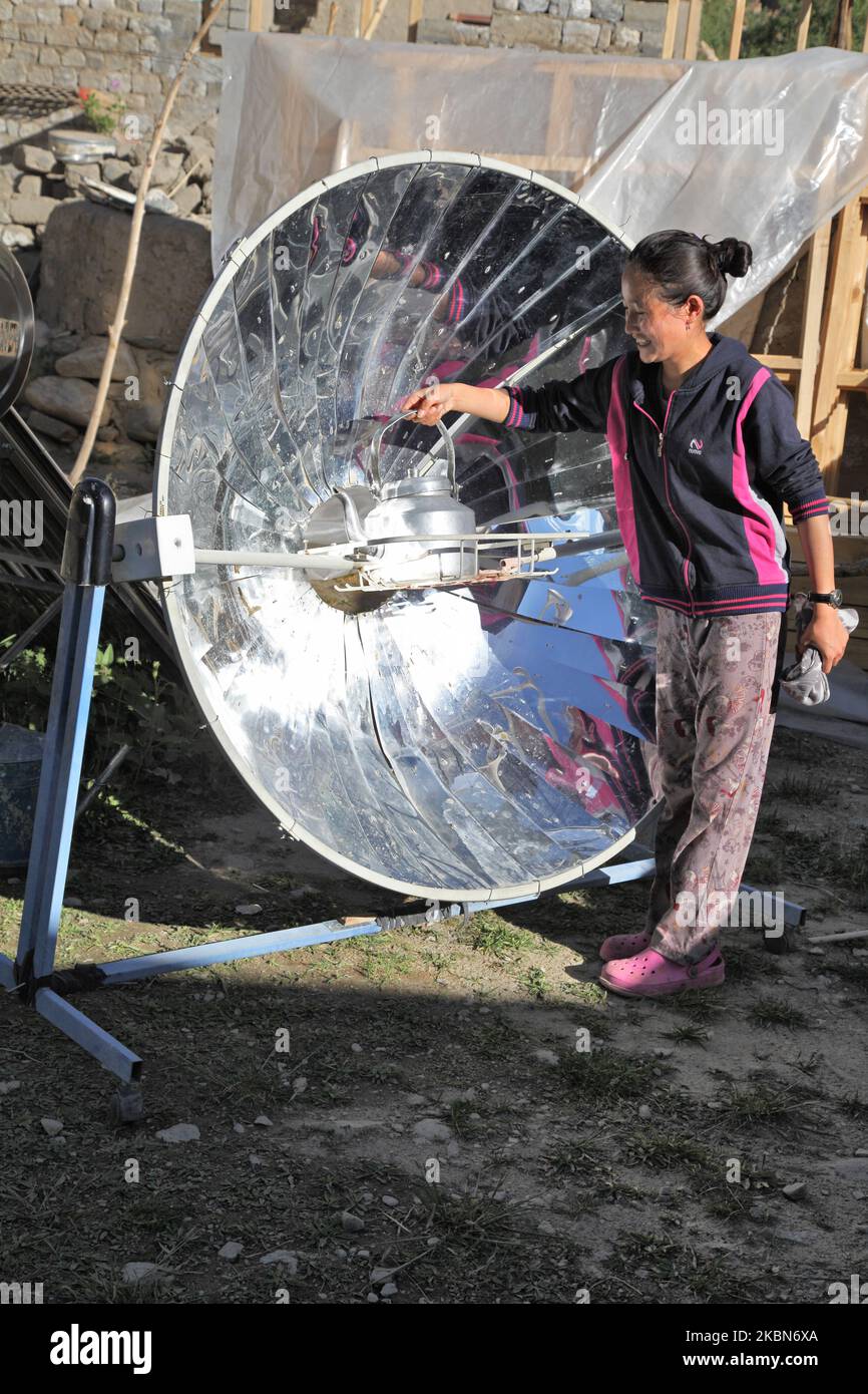 Ladakhi girl uses a parabolic solar cooker to heat water for tea ...