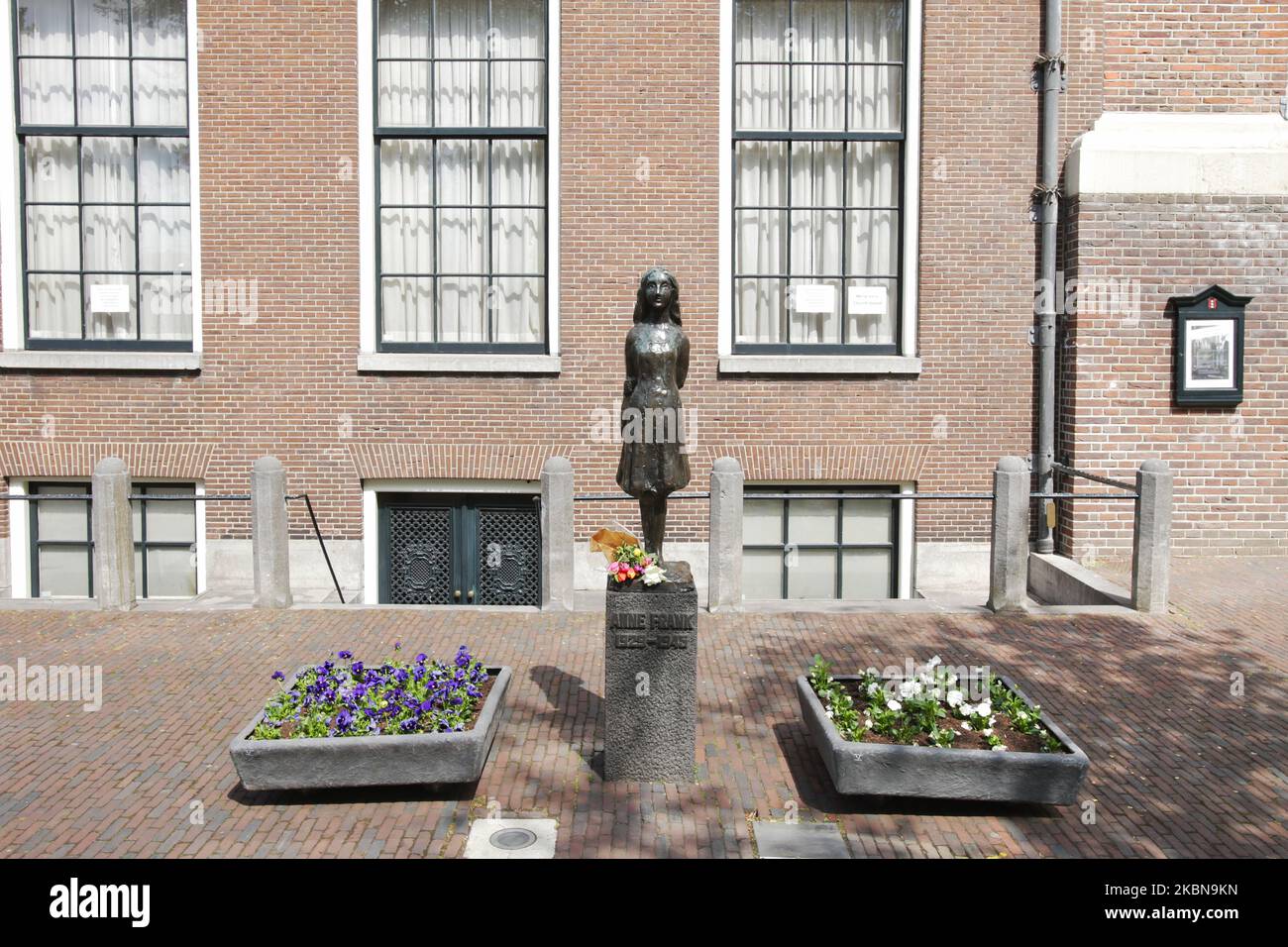 Flowers laid at the Anne Frank (1929-1945) statue near Anne Frank house ...