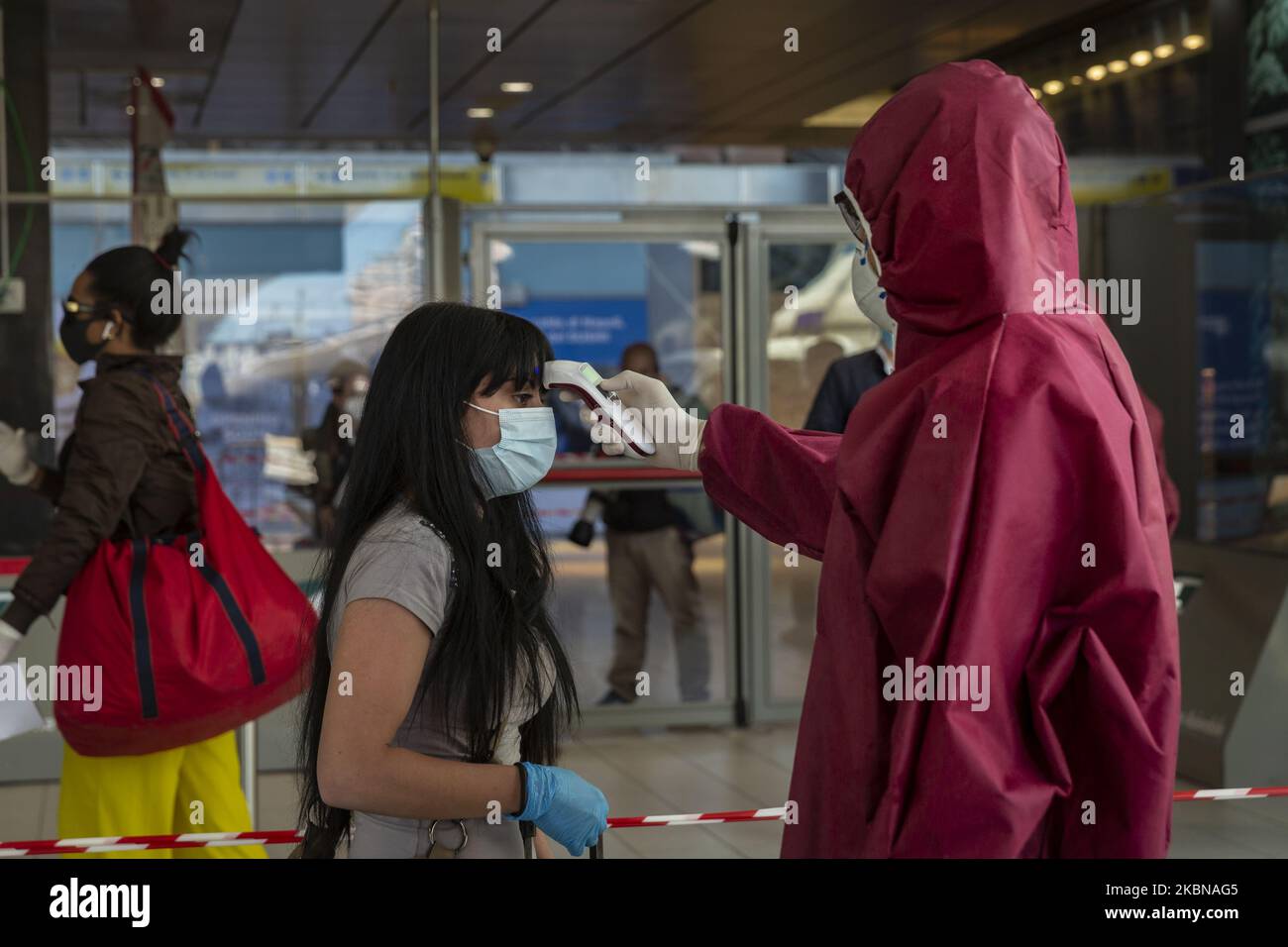 A traveller is being taken a temperature check upon the arrival at ...