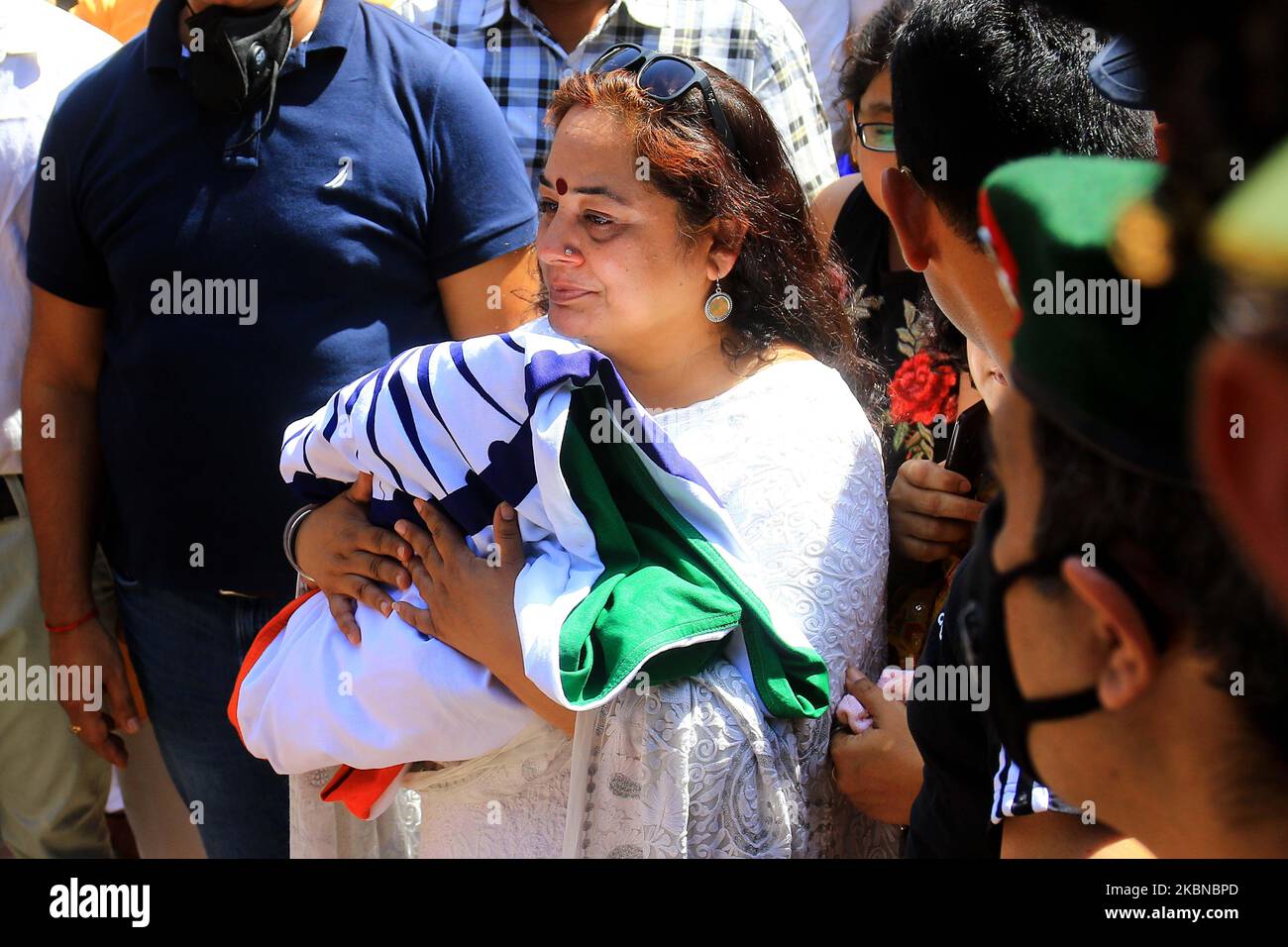 Wife of Colonel. Ashutosh Sharma reacts as she holds the tricolor ...