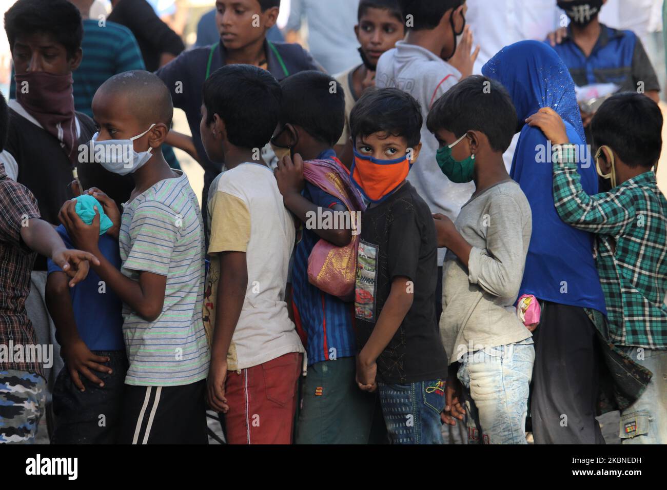 Children queue to collect free food at a slum in Mumbai, India on May ...