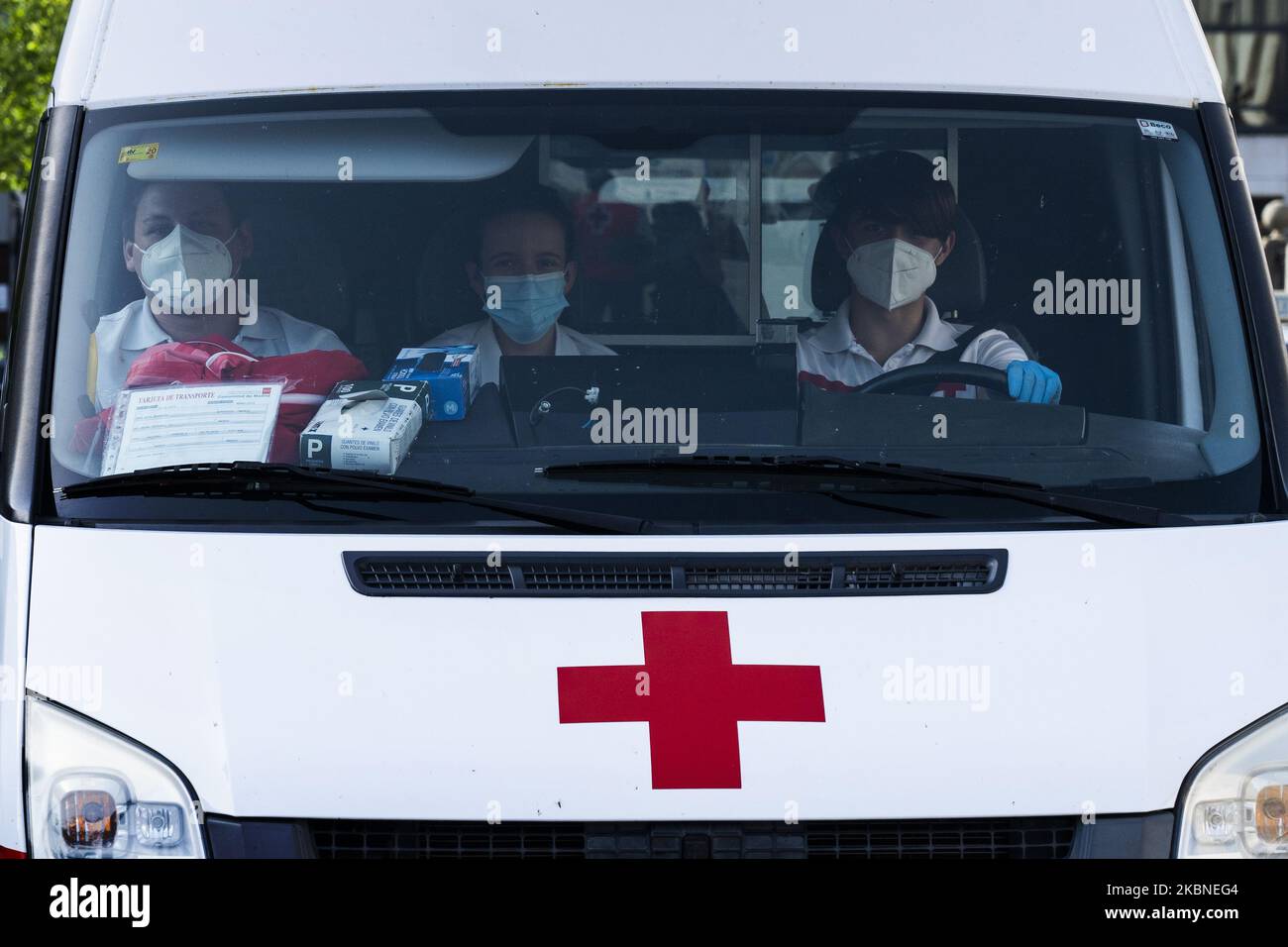 Red Cross members protected with their masks inside an ambulance ...
