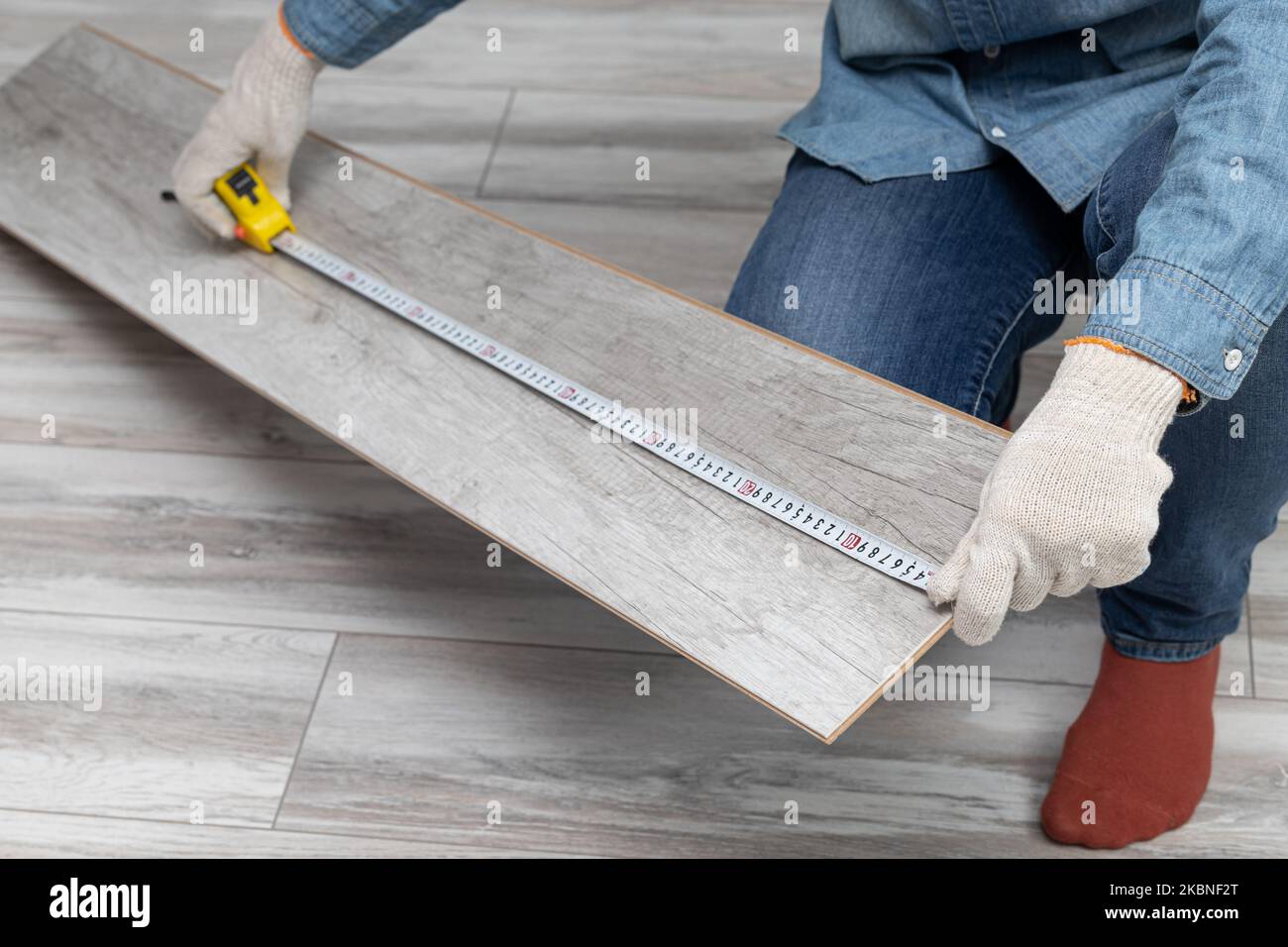 a man measures the length of a board with a tape measure Stock Photo ...