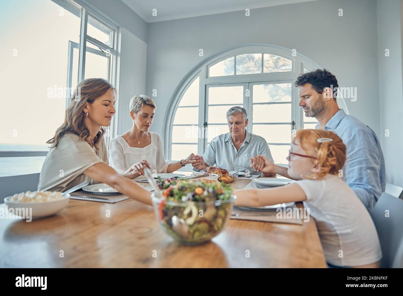 Lunch, praying and family together at dining room table in home ...