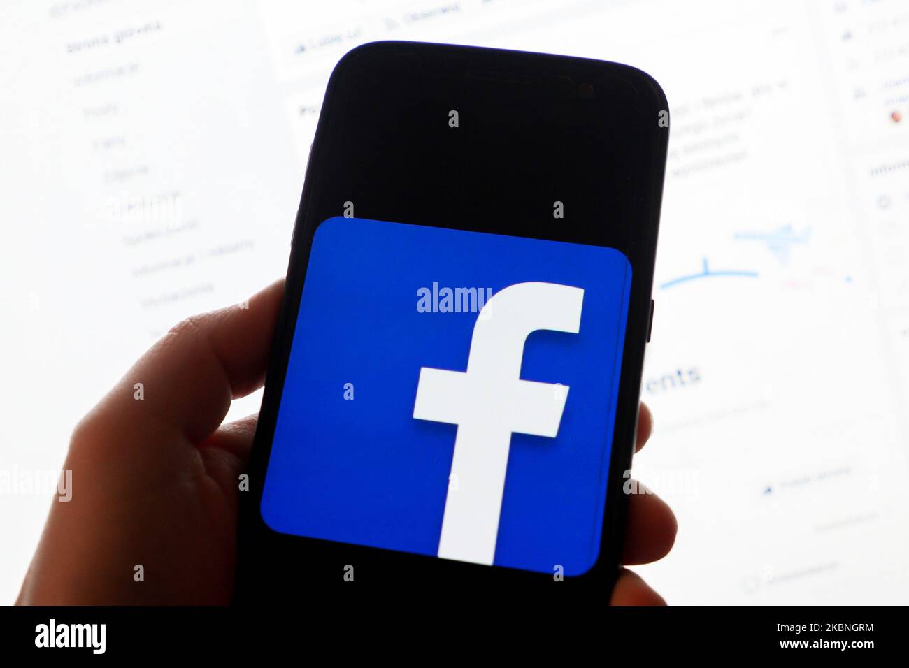 Facebook logo is displayed on a mobile phone screen photographed for ...