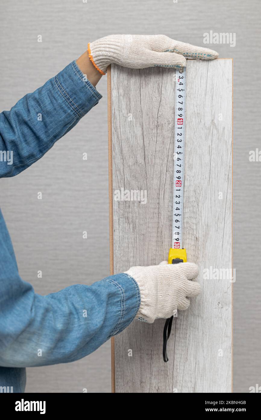 a man measures the length of a board with a tape measure Stock Photo ...