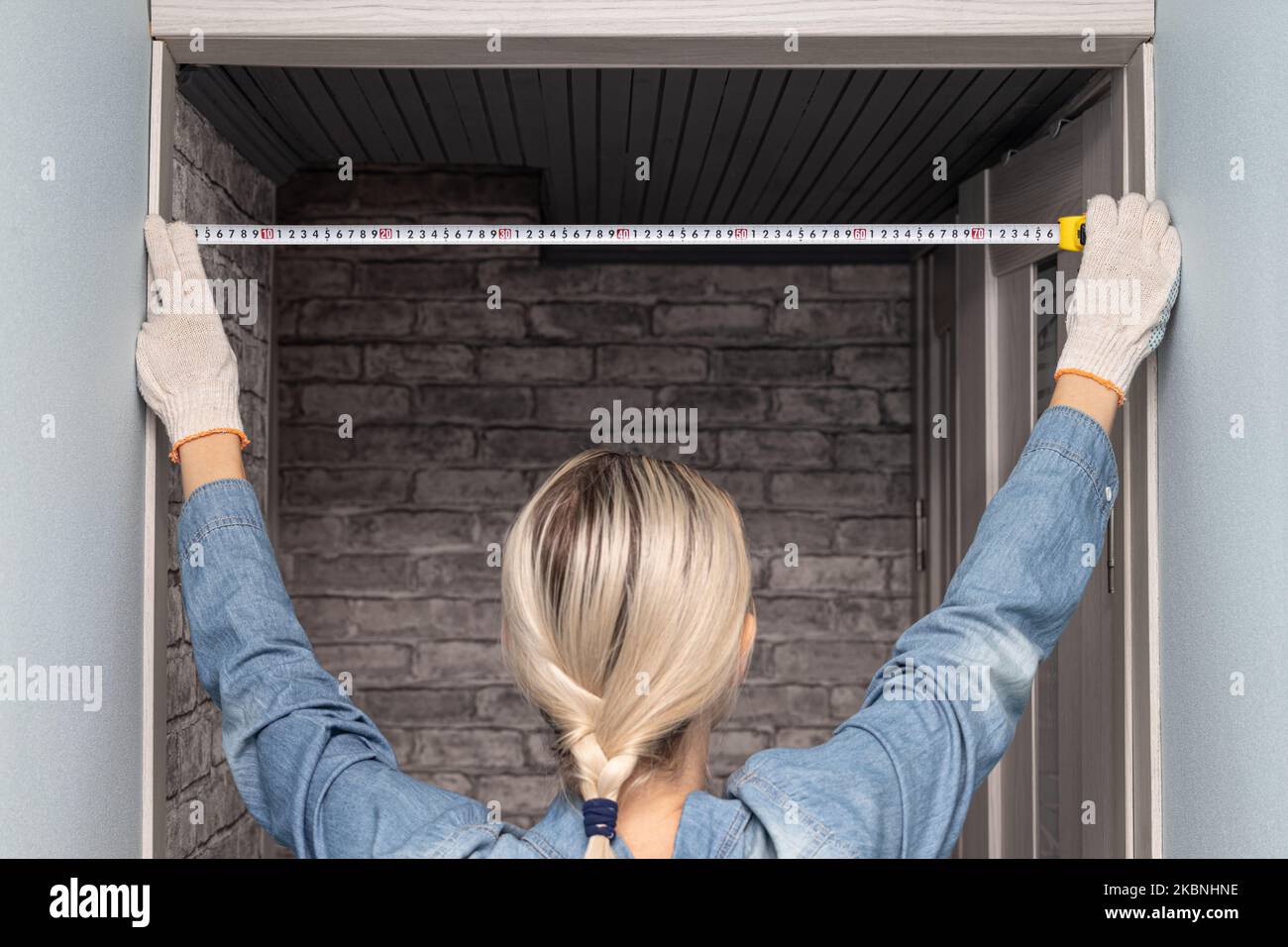 woman measuring a doorway with a tape measure. woman using a tape ...